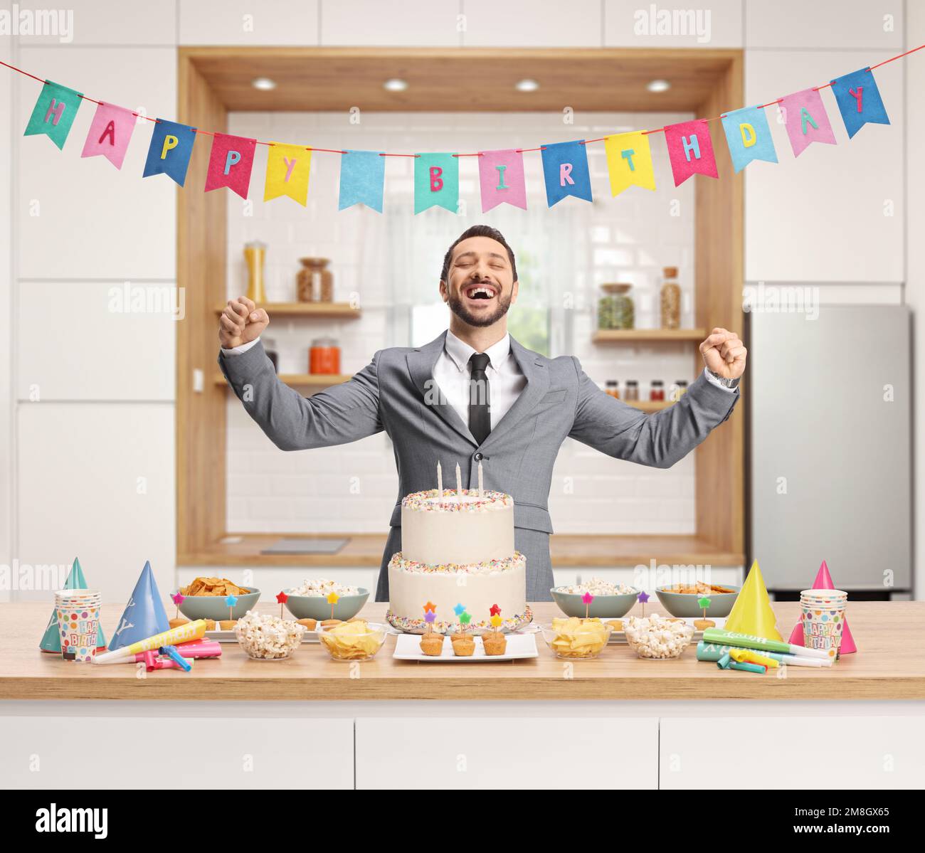 Man in a suit and tie standing inside a kitchen and celebrating ...