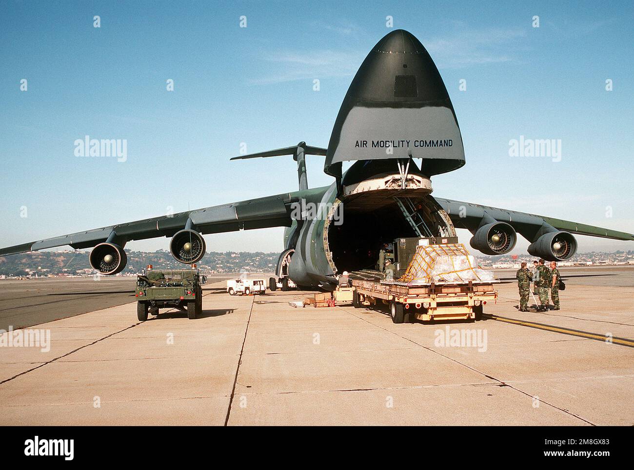 Members of a load crew load pallets of cargo from a K-Loader onto a C ...