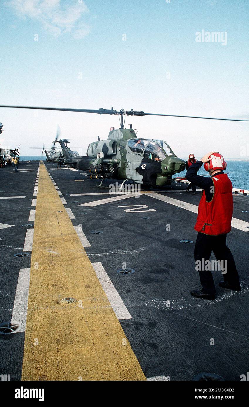 A flight deck crew member stands by as a Marine Medium Helicopter ...
