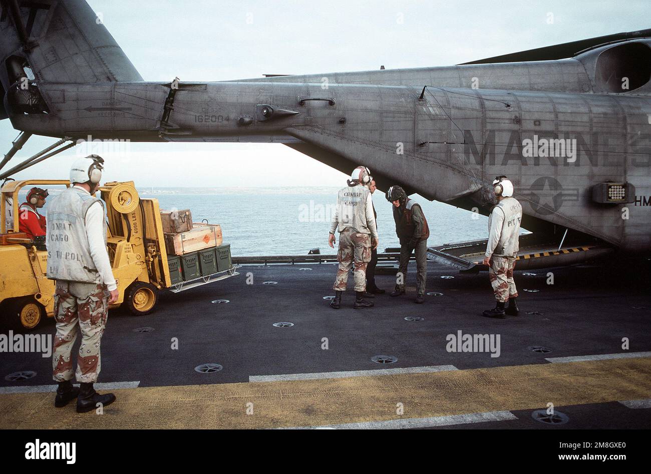 Marine flight deck personnel confer with crew members of a Marine ...