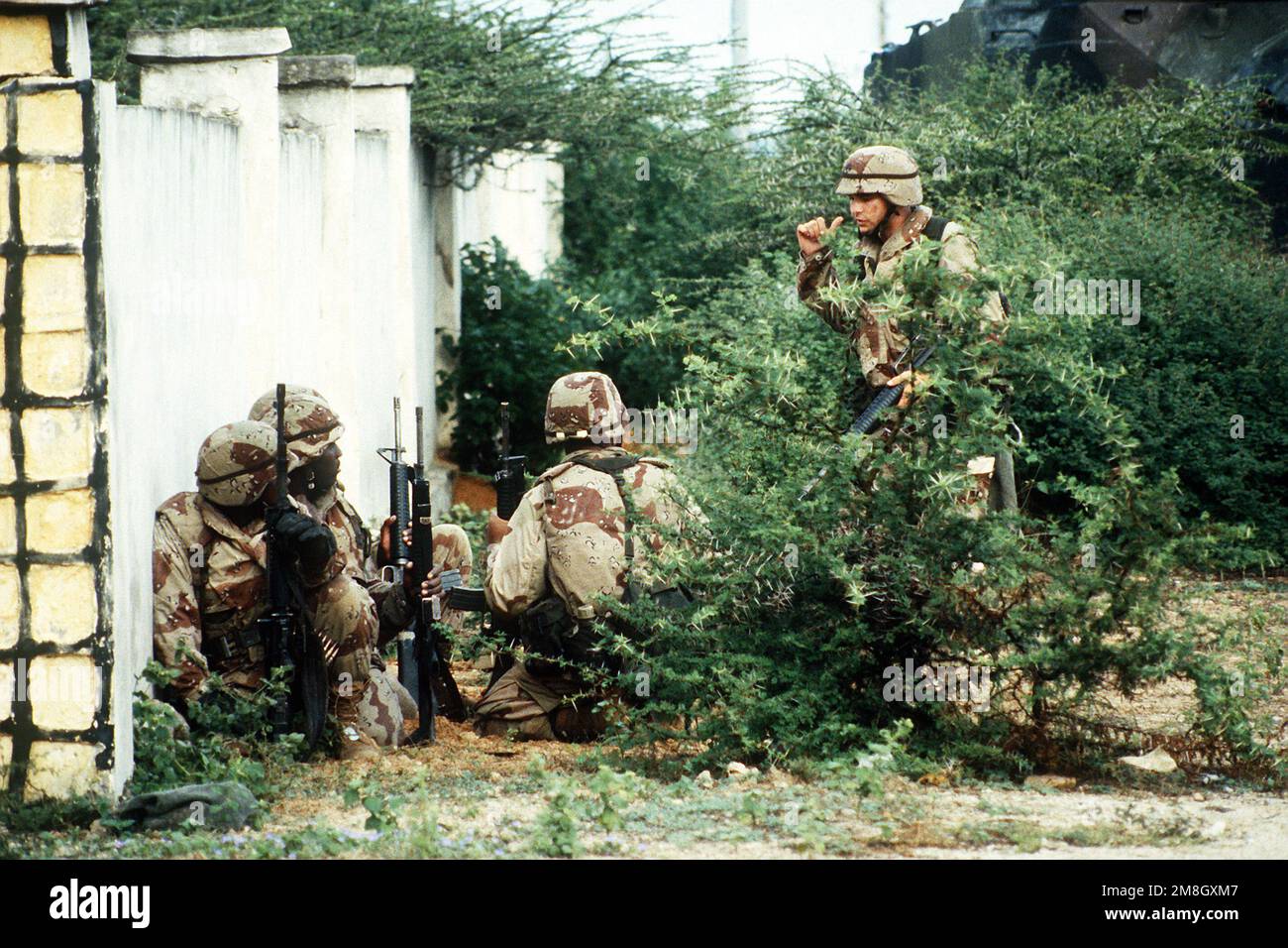Marines prepare to advance during a raid on a weapons cache during the multinational relief ...