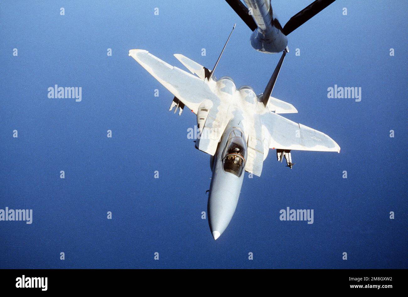 Aerial view as USAF F-15 Eagle fighter moves into position for aerial refueling by a KC-135 ...