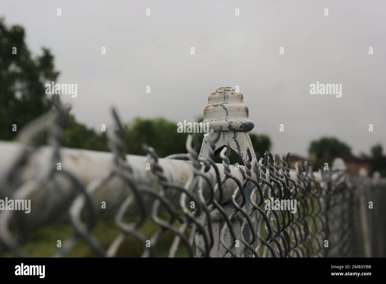 An old typical industrial metal chain link fence and post Stock Photo ...