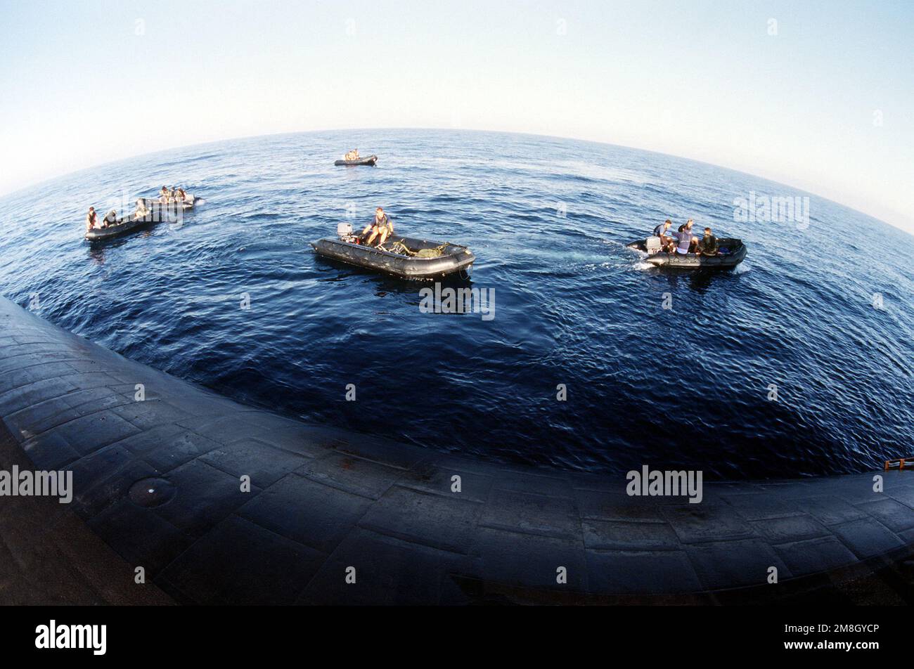 Five Zodiac boats, with members of SEAL Team One embarked stand by off ...