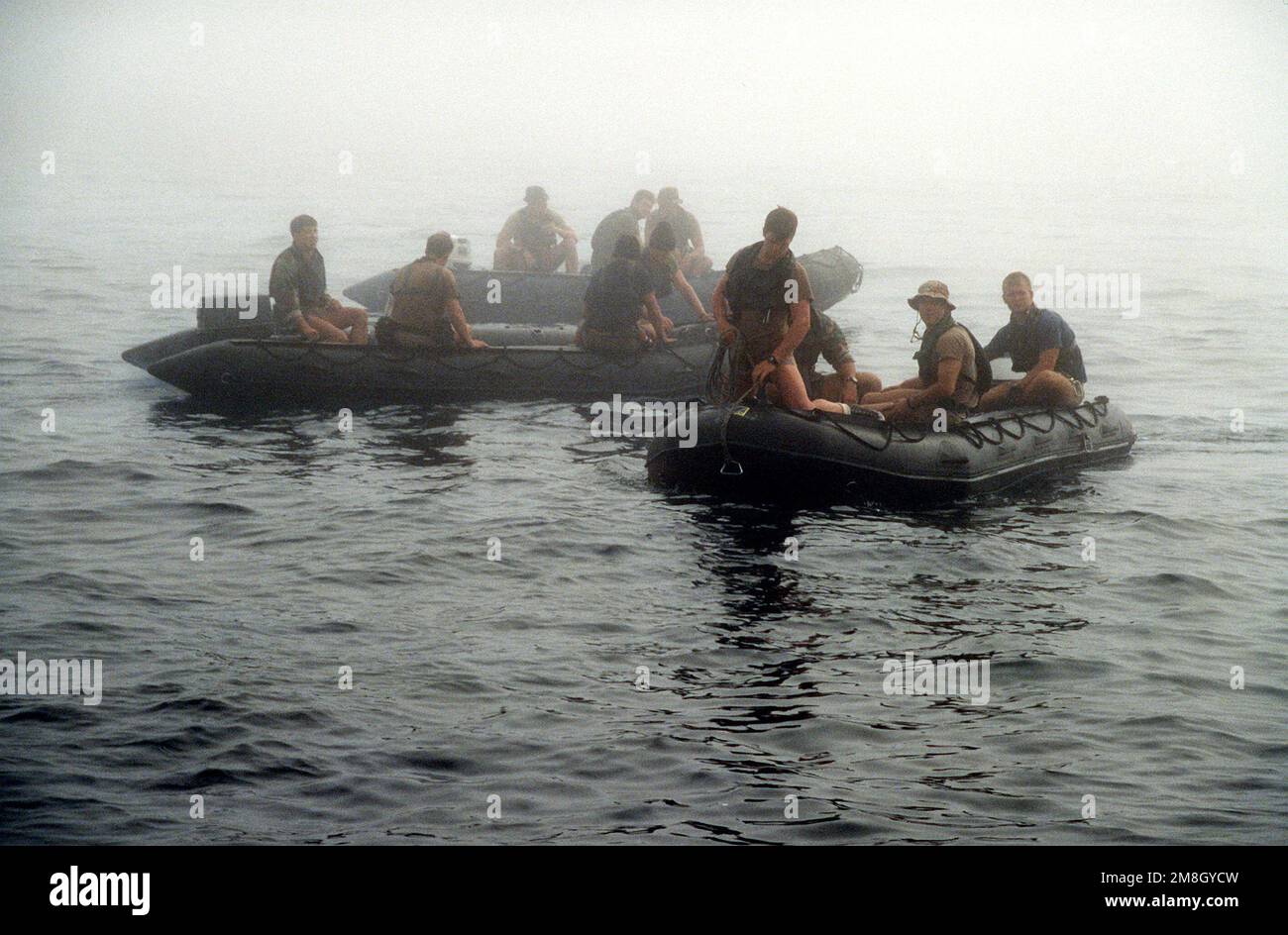 Members of SEAL Team, one are shown standing by in Zodiac boats, in the ...