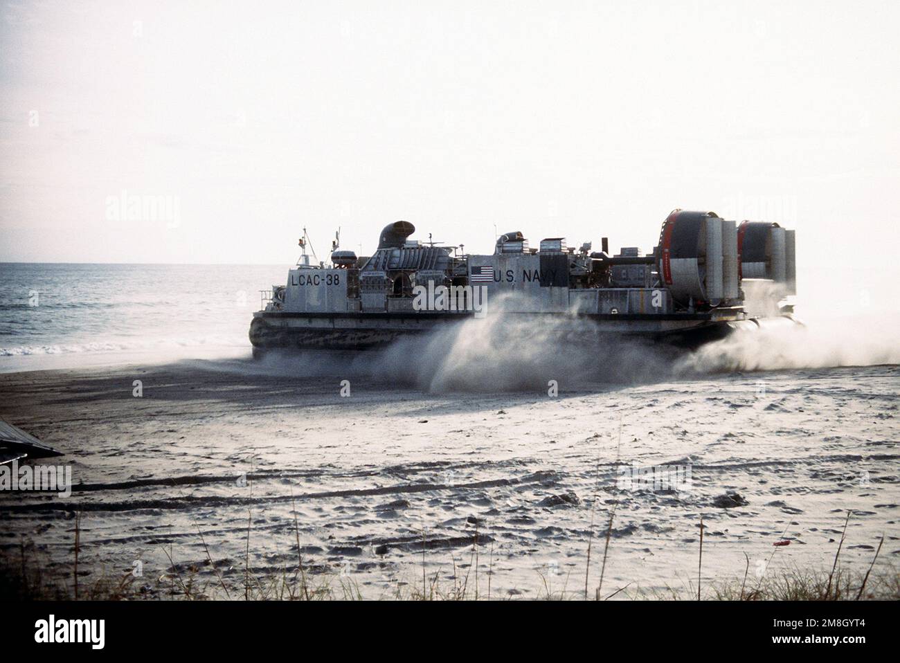A Navy Landing Craft Air Cushion (LCAC) vehicle, #38, moves across the ...