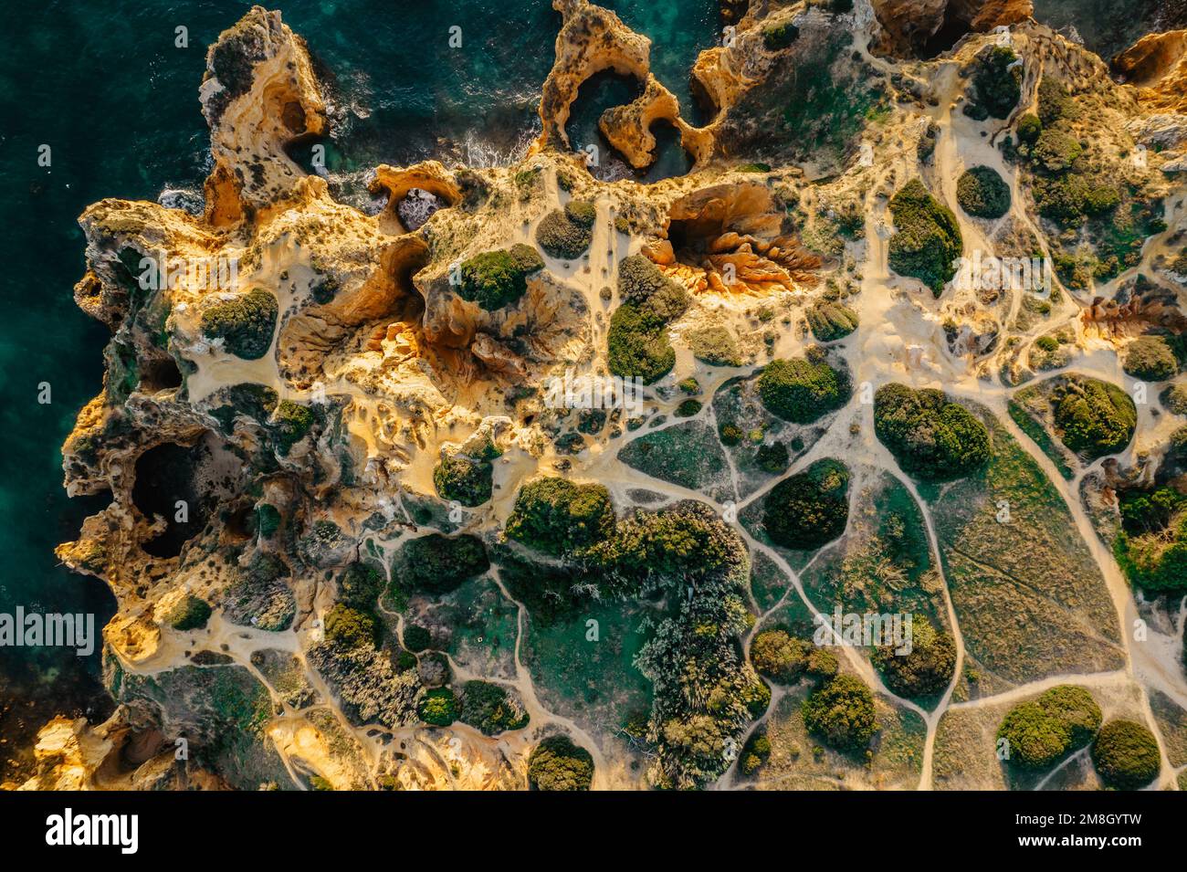 Aerial view of coastal golden cliffs at sunrise in Ponta da Piedade ...