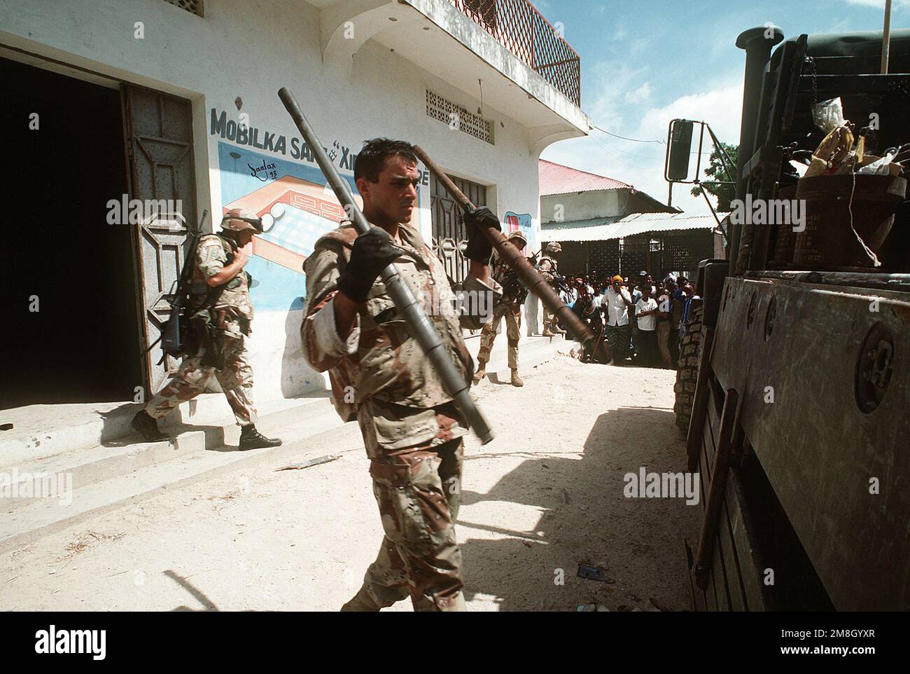 A Marine carries machine gun barrels confiscated during the ... A Marine carries machine gun barrels confiscated during the ...