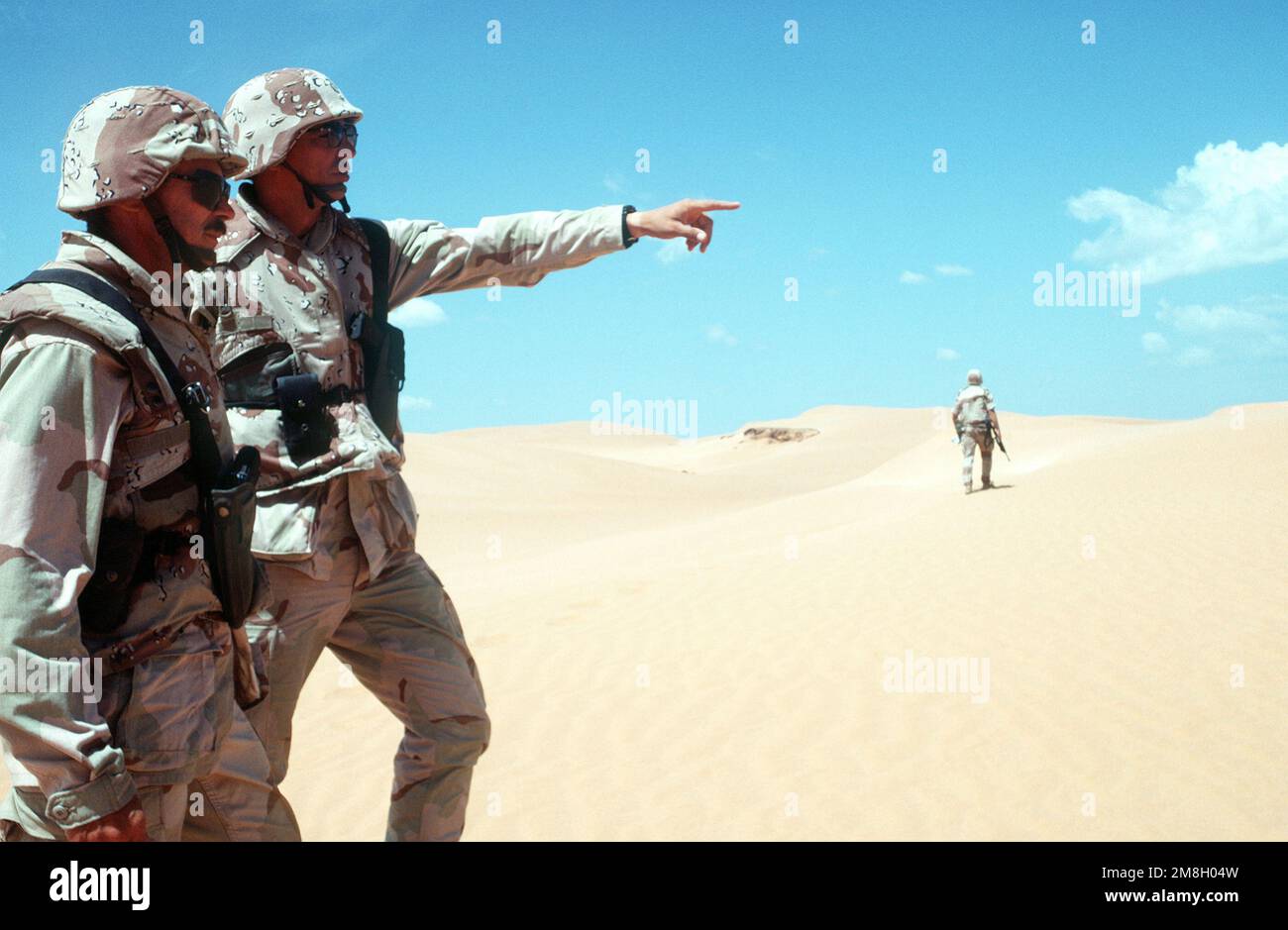 Explosive ordnance disposal (EOD) technicians survey the desert outside ...