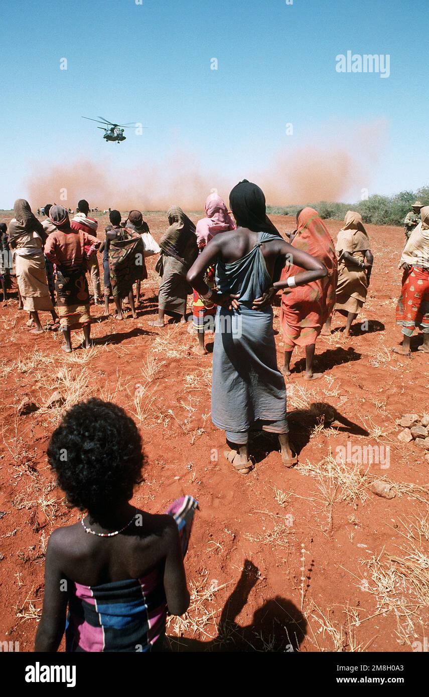 Villagers watch as a Marine Heavy Helicopter Squadron 363 (HMH-363) CH ...