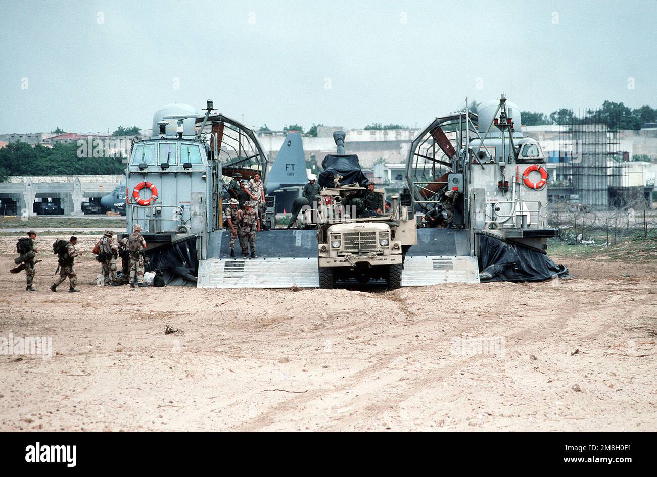 A Marine truck, towing an 155mm M-198 howitzer, disembarks from an ...