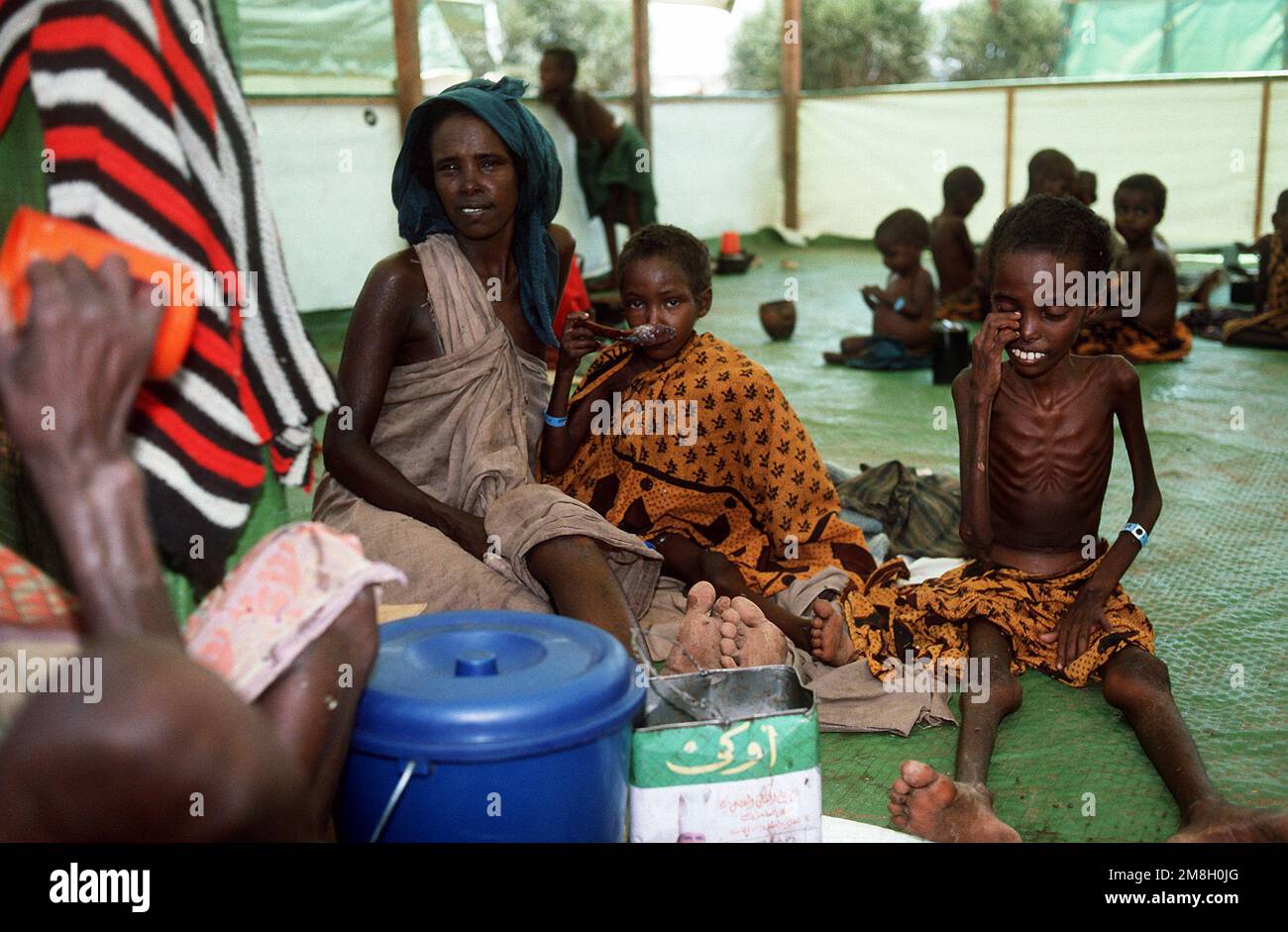 A Somali refugee child eats as he sits with his mother at an aid station during Operation ...
