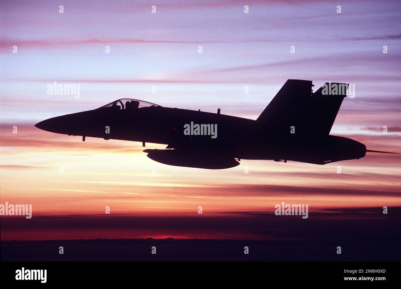 A silhouette of a Strike Fighter Squadron 136 (VFA-136) F/A-18C Hornet ...