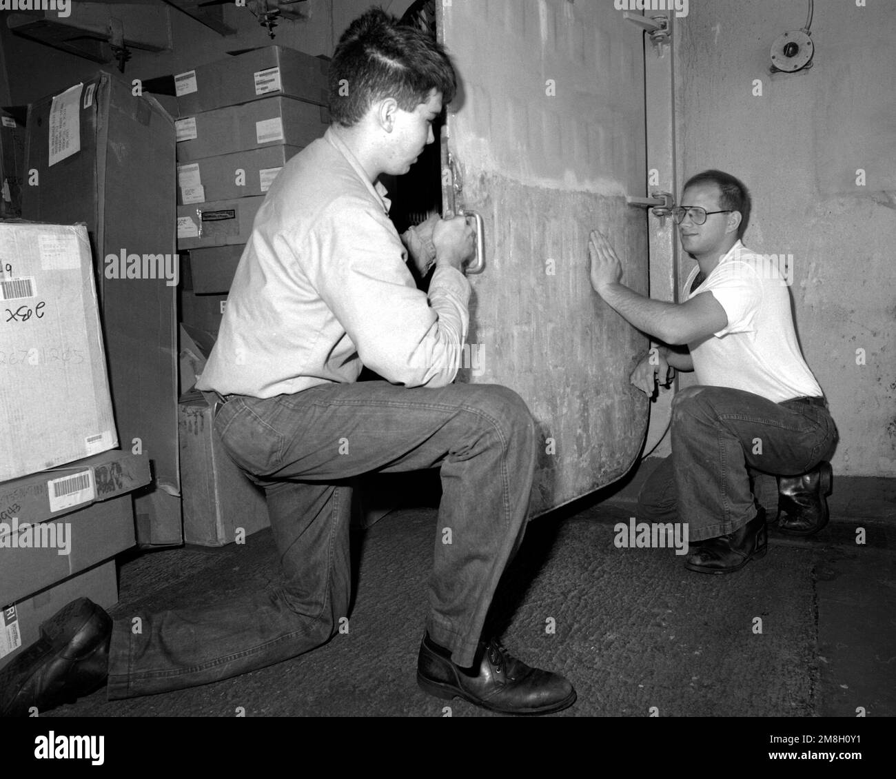 SEAMAN Matt McGuire, left, and SEAMAN Pat Borcheri sand the door to a ...