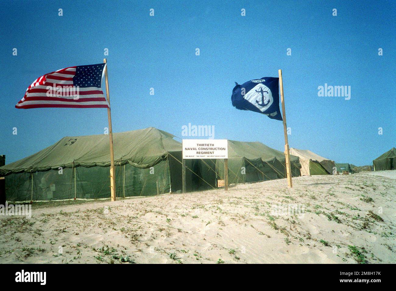The American flag and the flag of the 30th Naval Construction Regiment ...