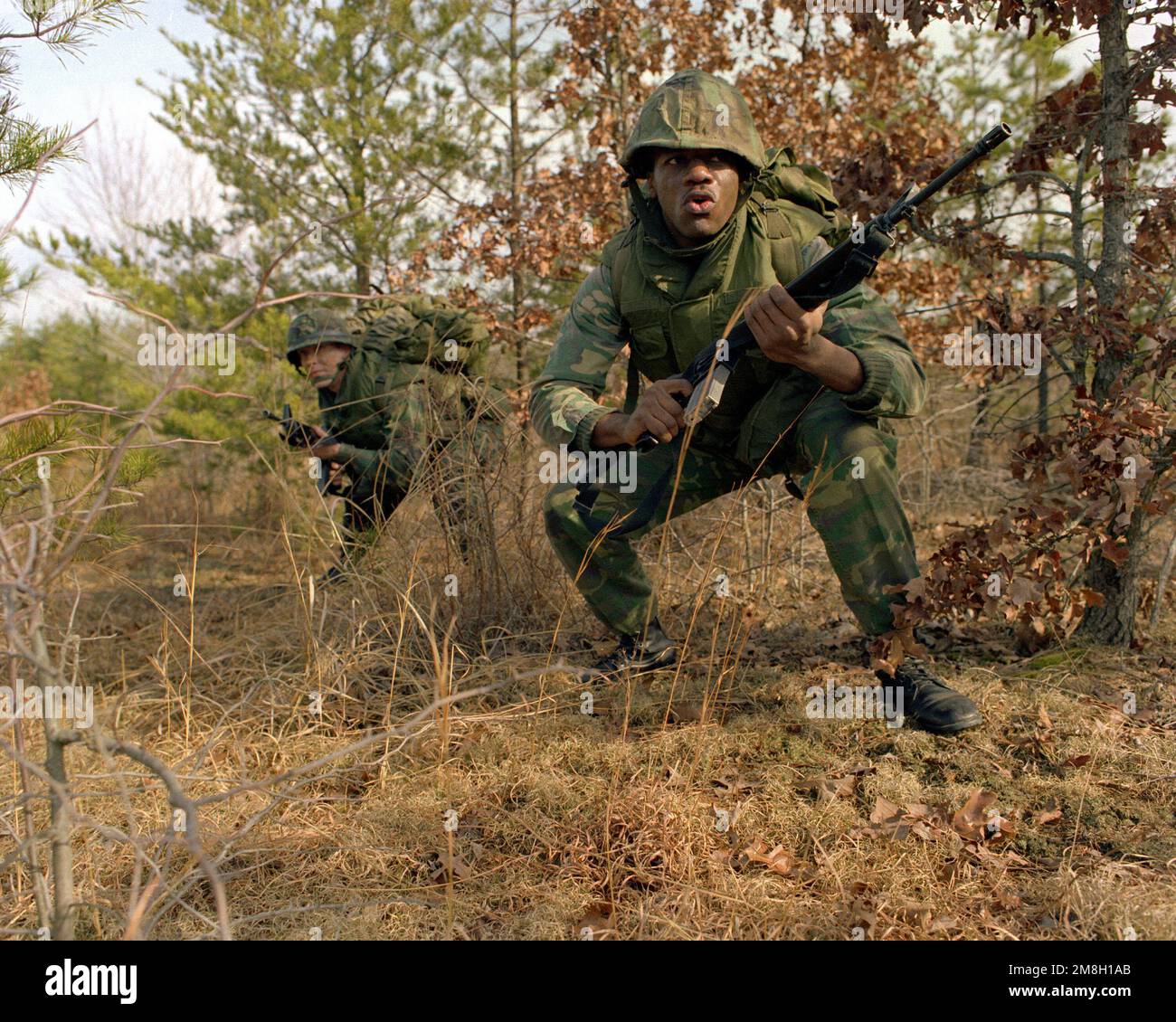 A pair of Marines armed with 5.56mm M-16A1 rifles advance during a ...