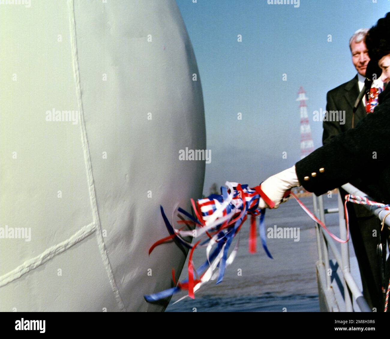 Mrs. John R. Dailey prepares to break the traditional champagne bottle ...