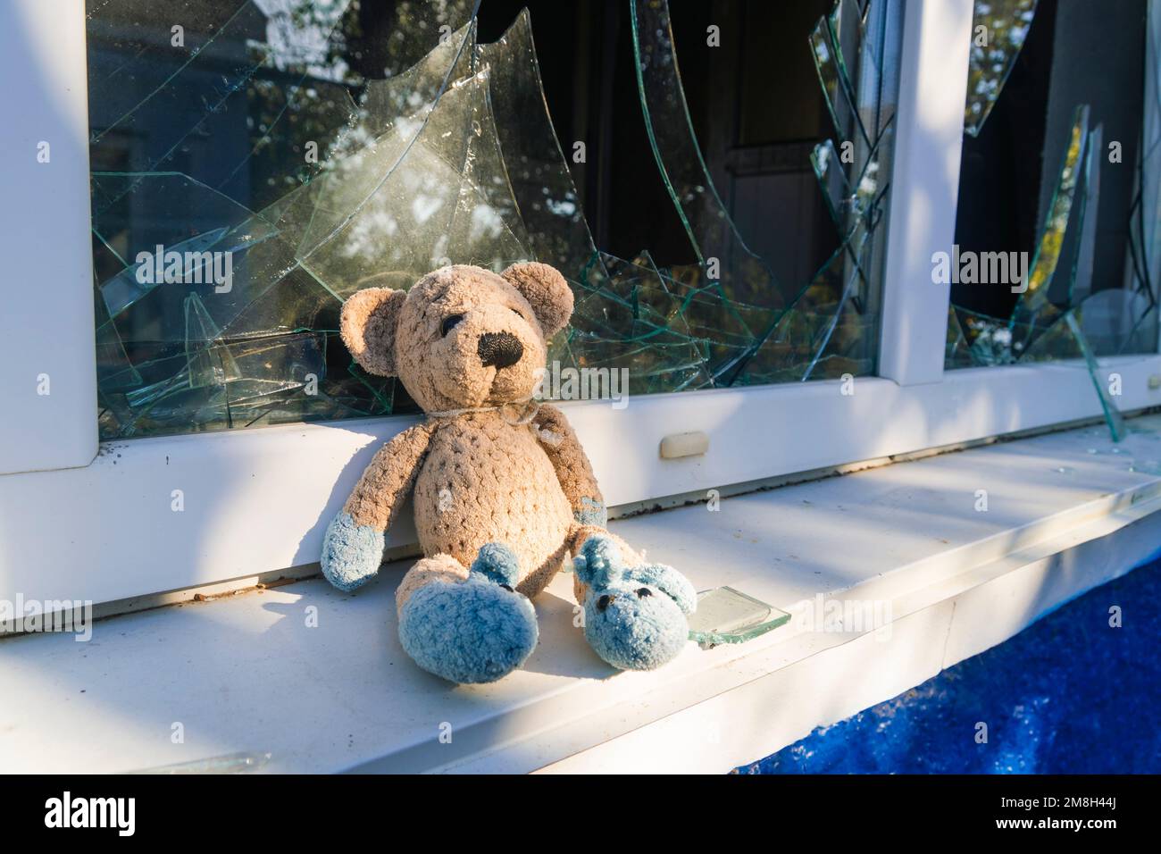 The toy (teddy bear) lies next to the broken window. War in Ukraine ...