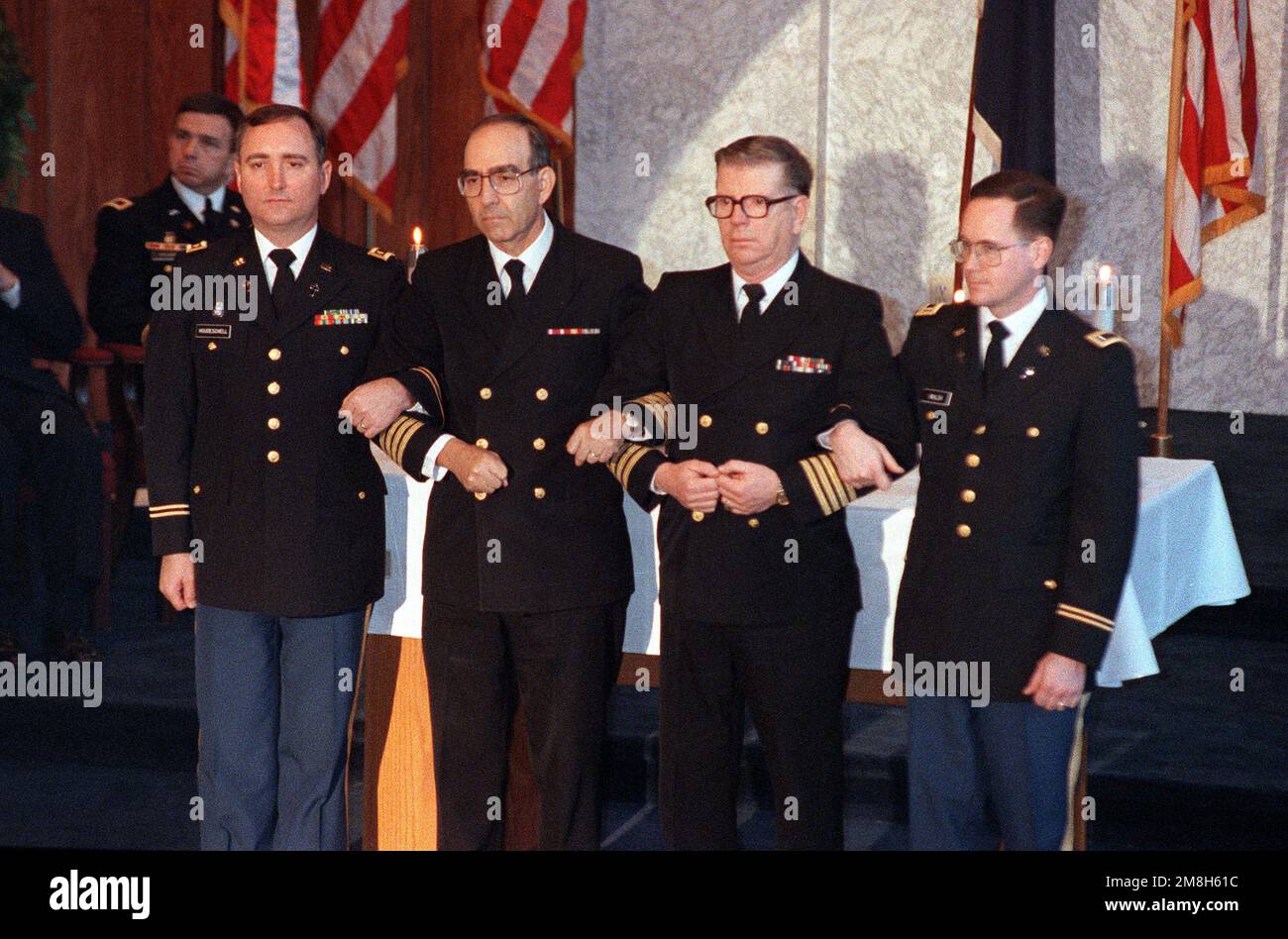 Chaplains link arms during a ceremony honoring four other chaplains who ...