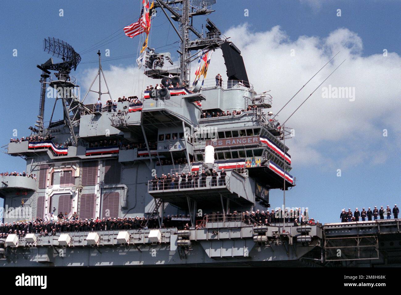 Sailors man the rails on the island of the aircraft carrier USS RANGER ...