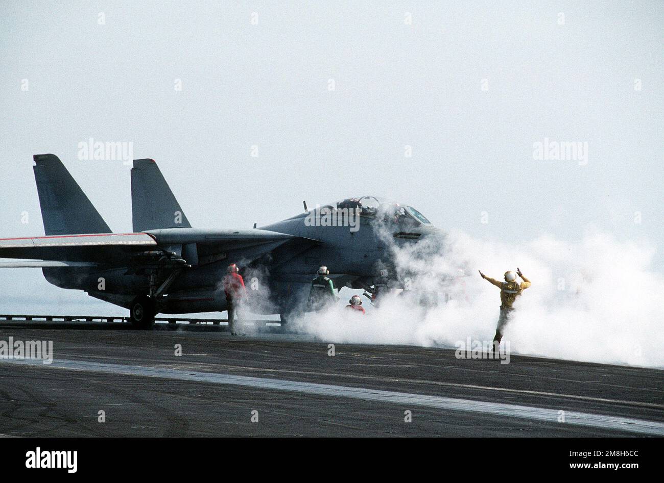 Steam from a previous launch rises from the catapult as an F-14A Tomcat ...