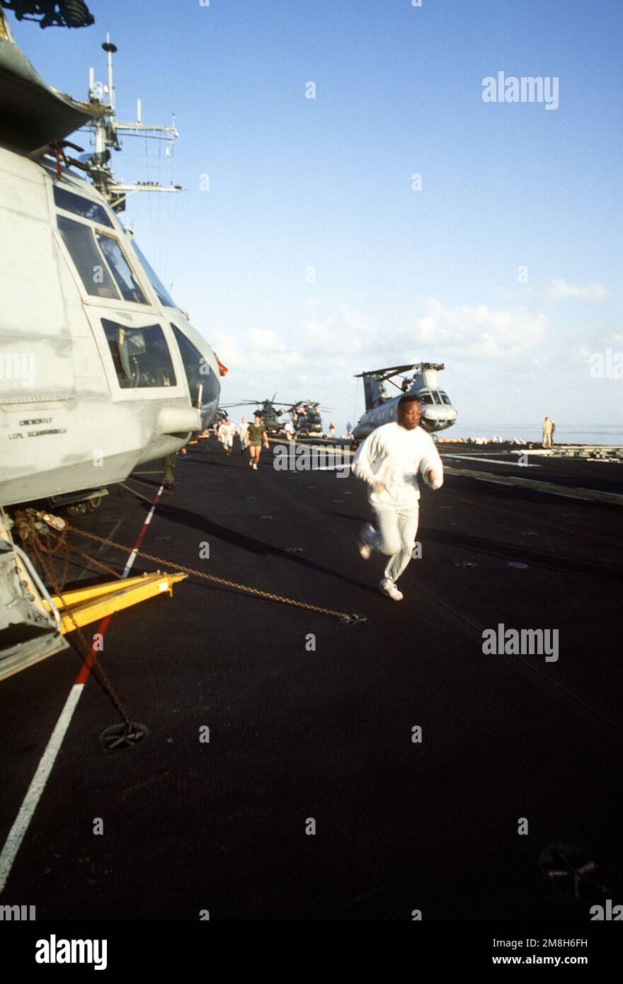 Members of the 22nd Marine Expeditionary Unit run on the flight deck of ...
