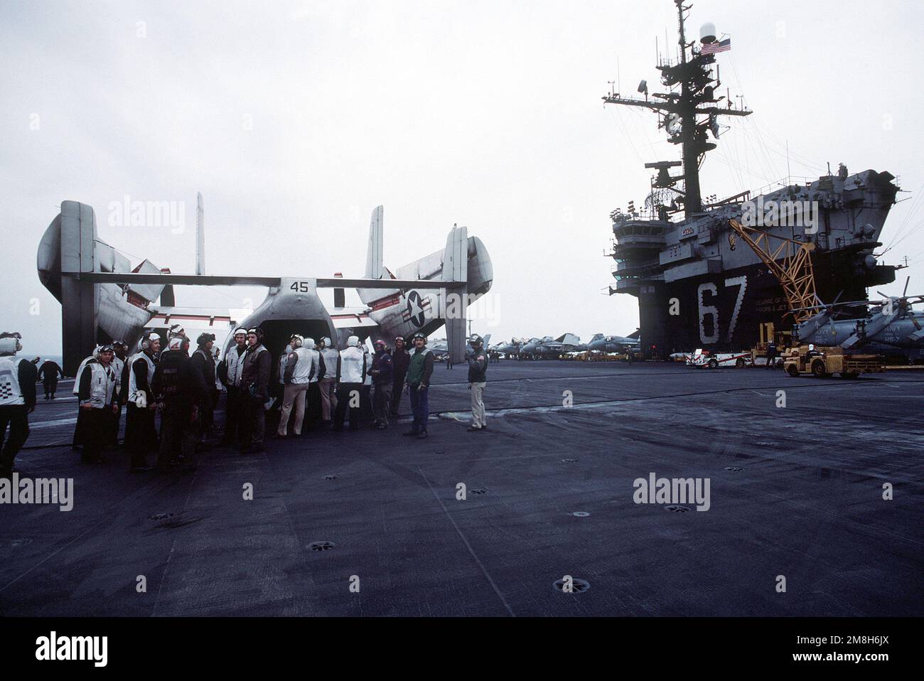Flight deck personnel watch as passengers board a Fleet Logistic ...