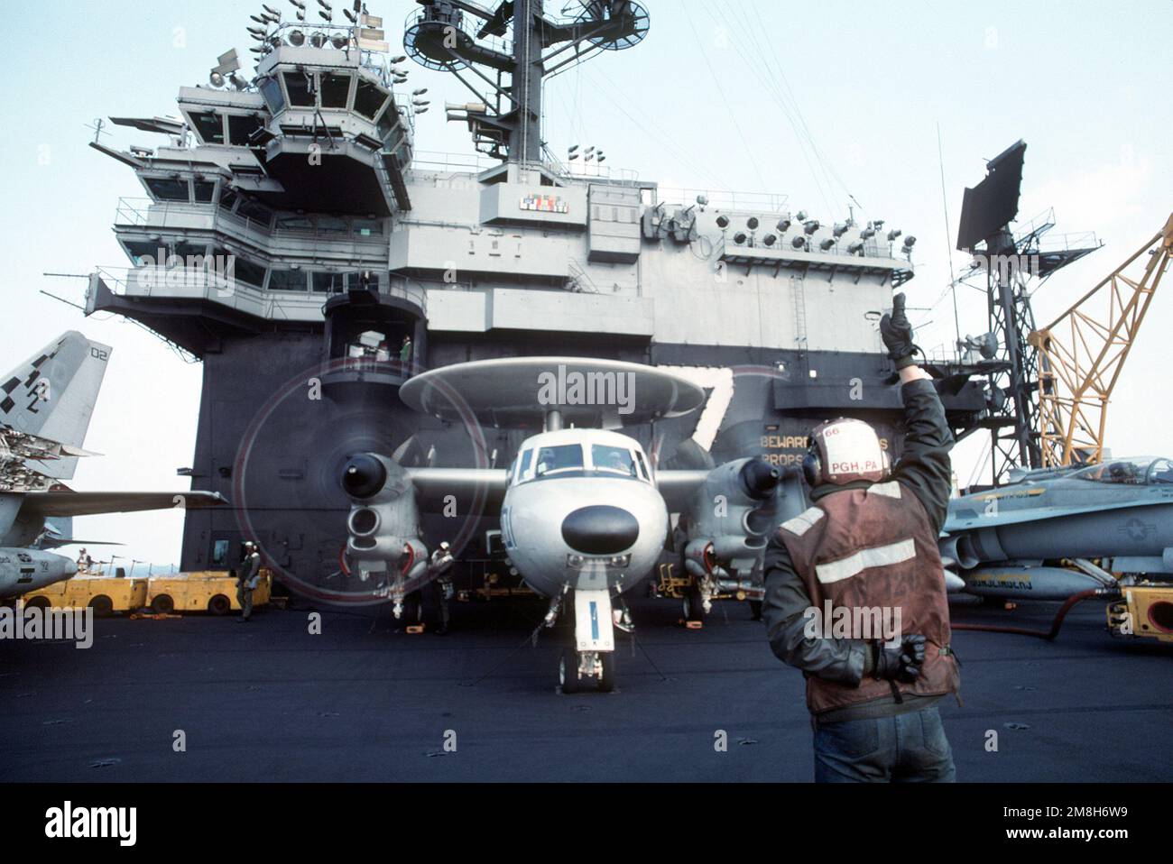 A plane captain signals to the pilot of an Airborne Early Warning ...