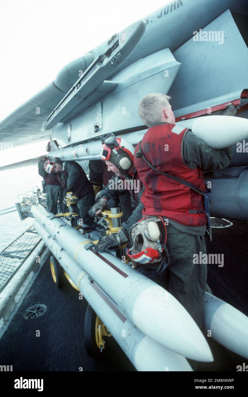 Aviation ordnancemen mount an AIM-7 Sparrow air-to-air missile on a ...