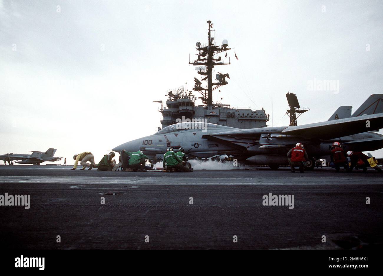 Members of the catapult crew take cover as a Fighter Squadron 14 (VF-14 ...