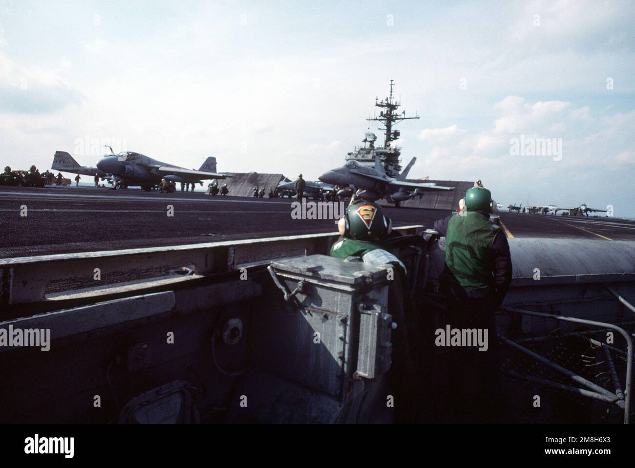 Members of the catapult crew watch from the deck edge operator's ...