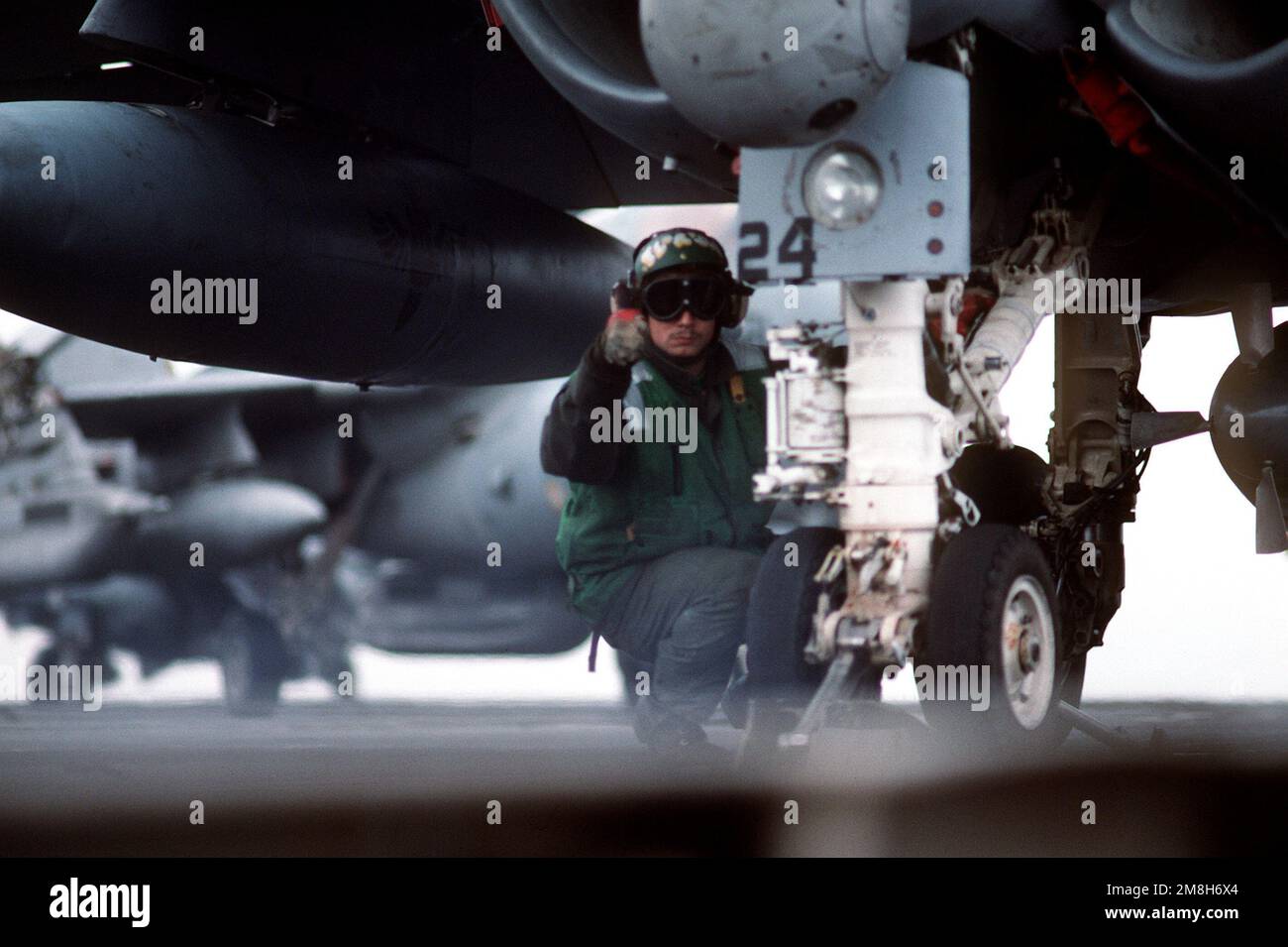 A member of the holdback/hookup crew signals to the catapult officer as ...