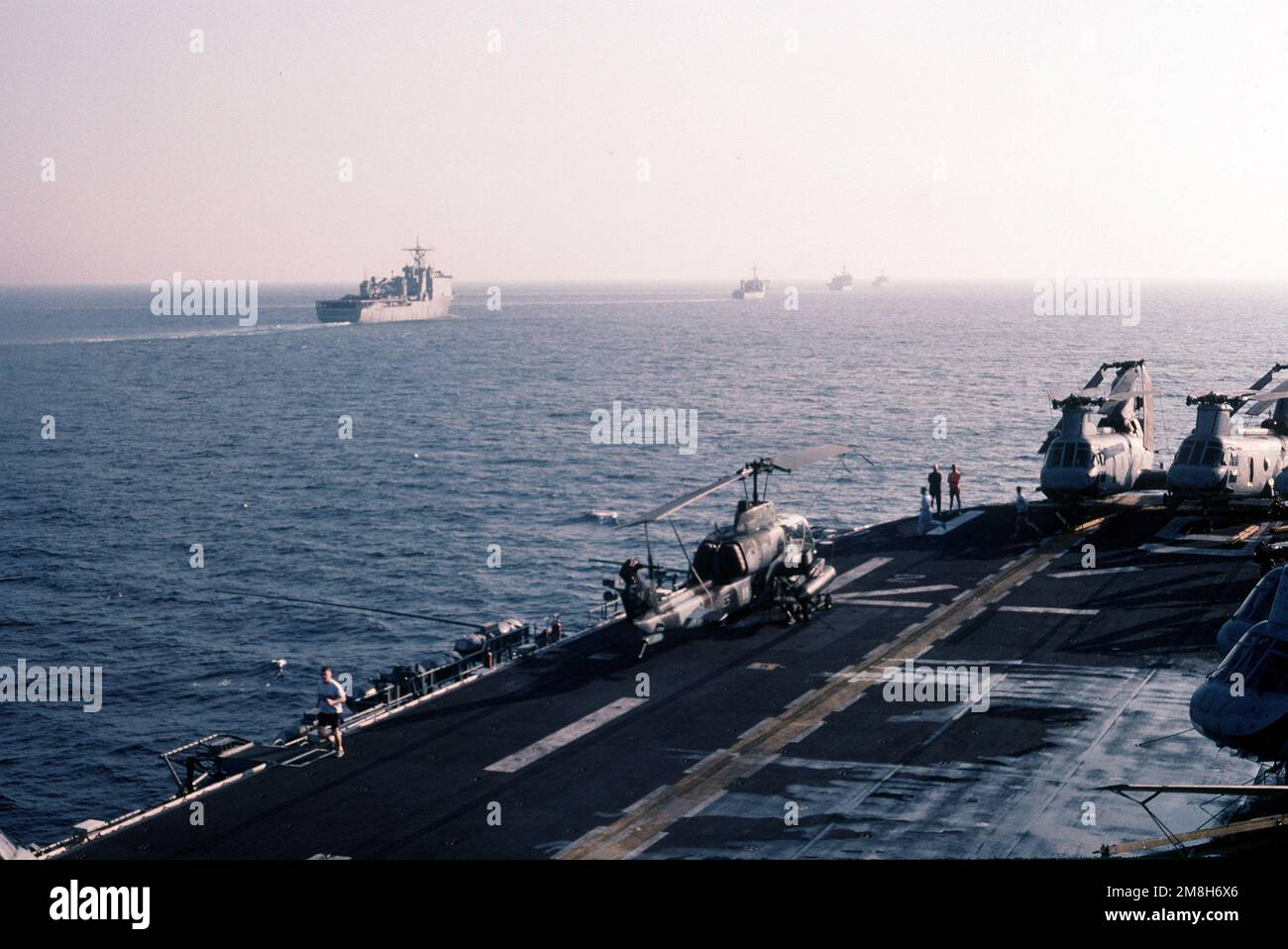 Marines run on the flight deck of the amphibious assault ship USS GUAM ...