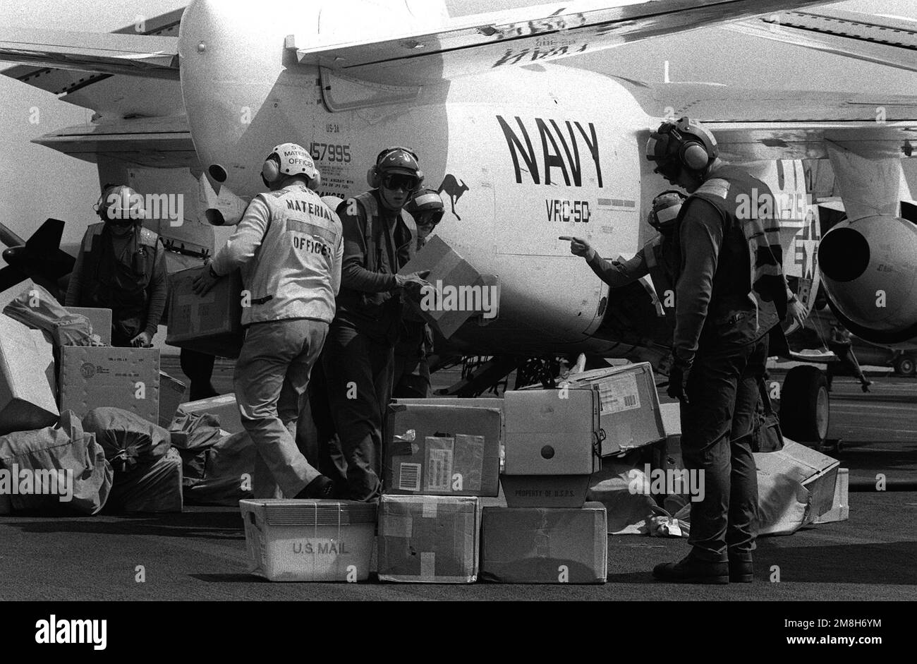 Flight deck crew members distribute mail and packages transported to ...