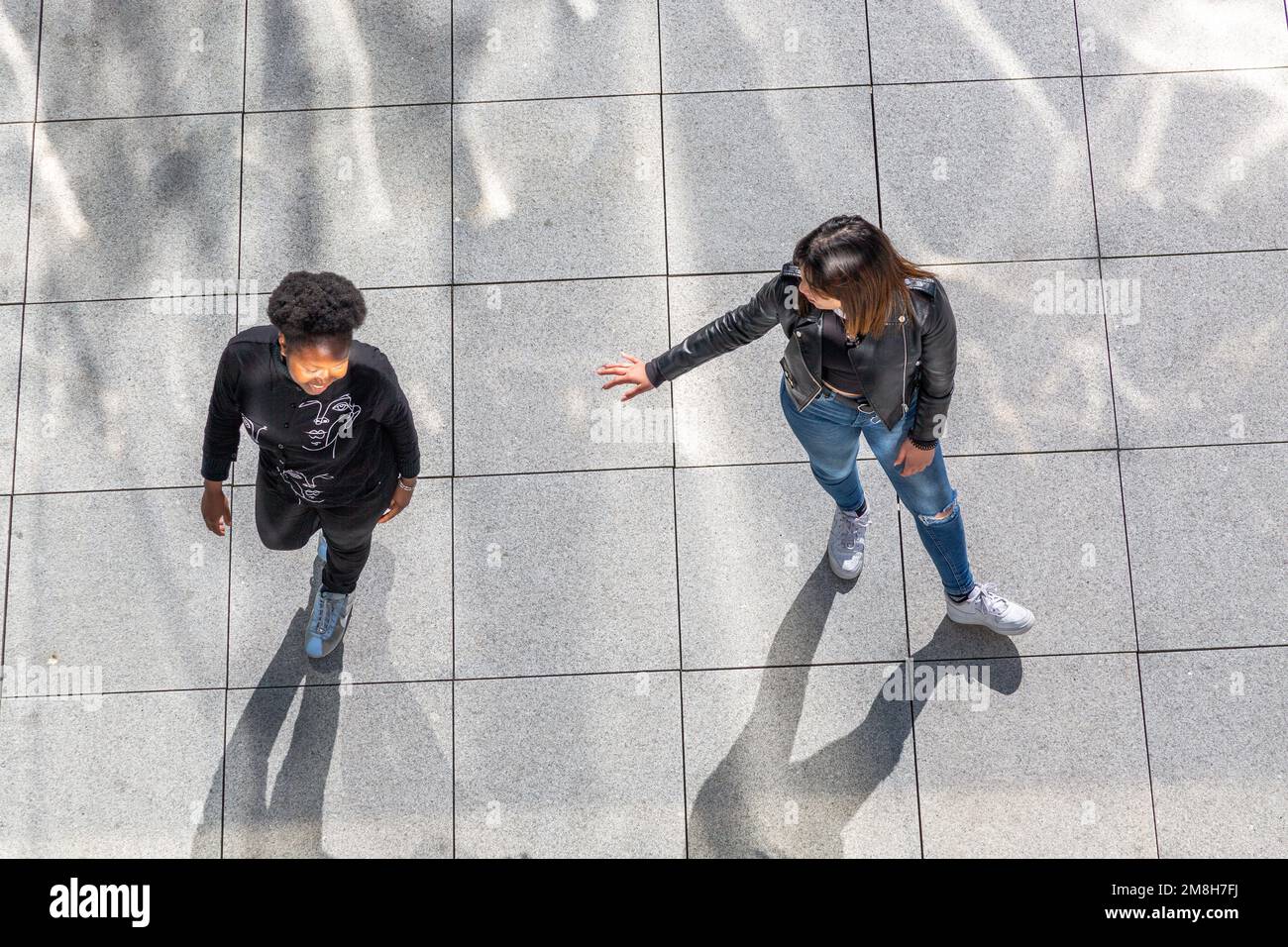 Bird's eye view of two young women illuminated by multiple reflections ...