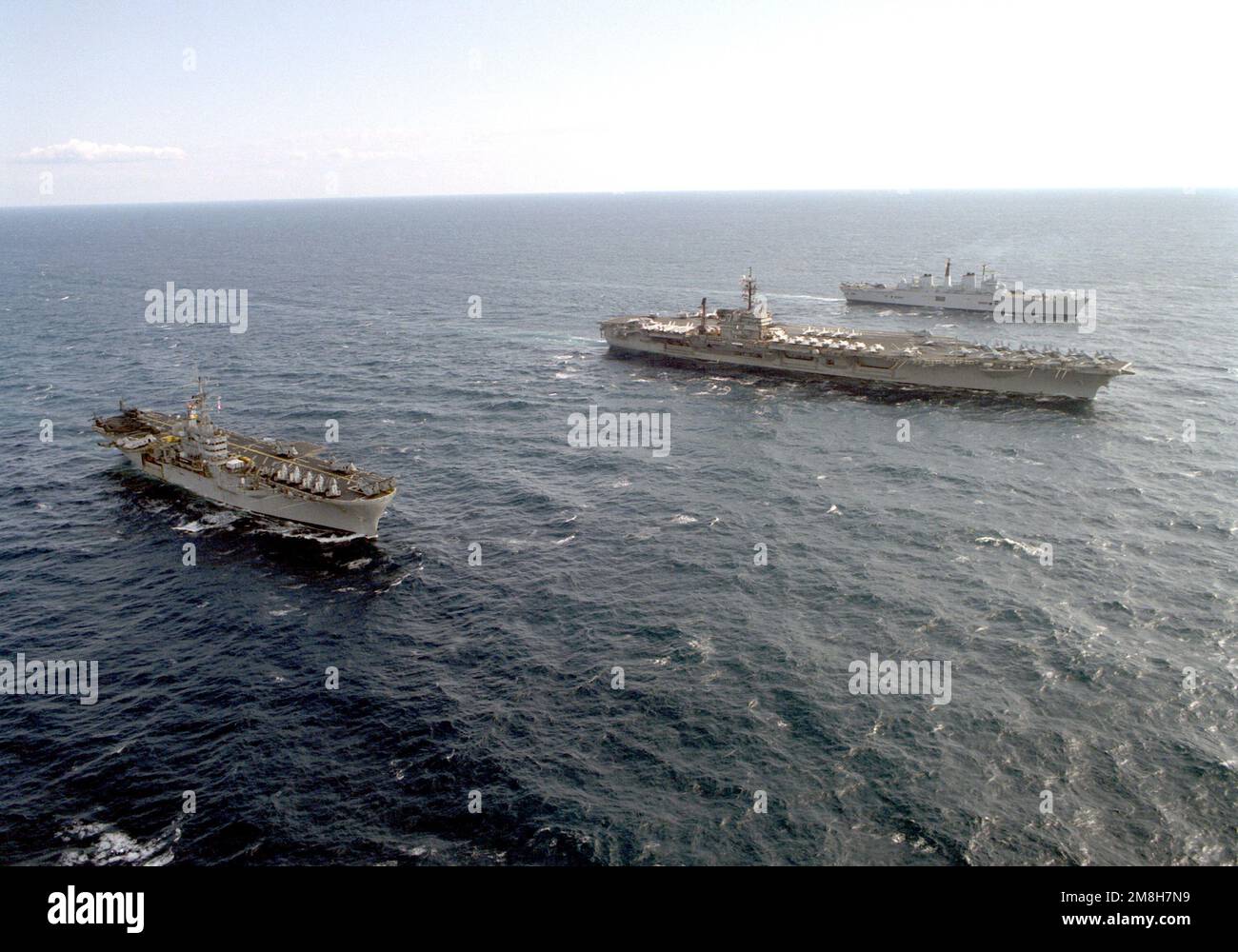 A port view of, from left to right, the amphibious assault ship USS ...