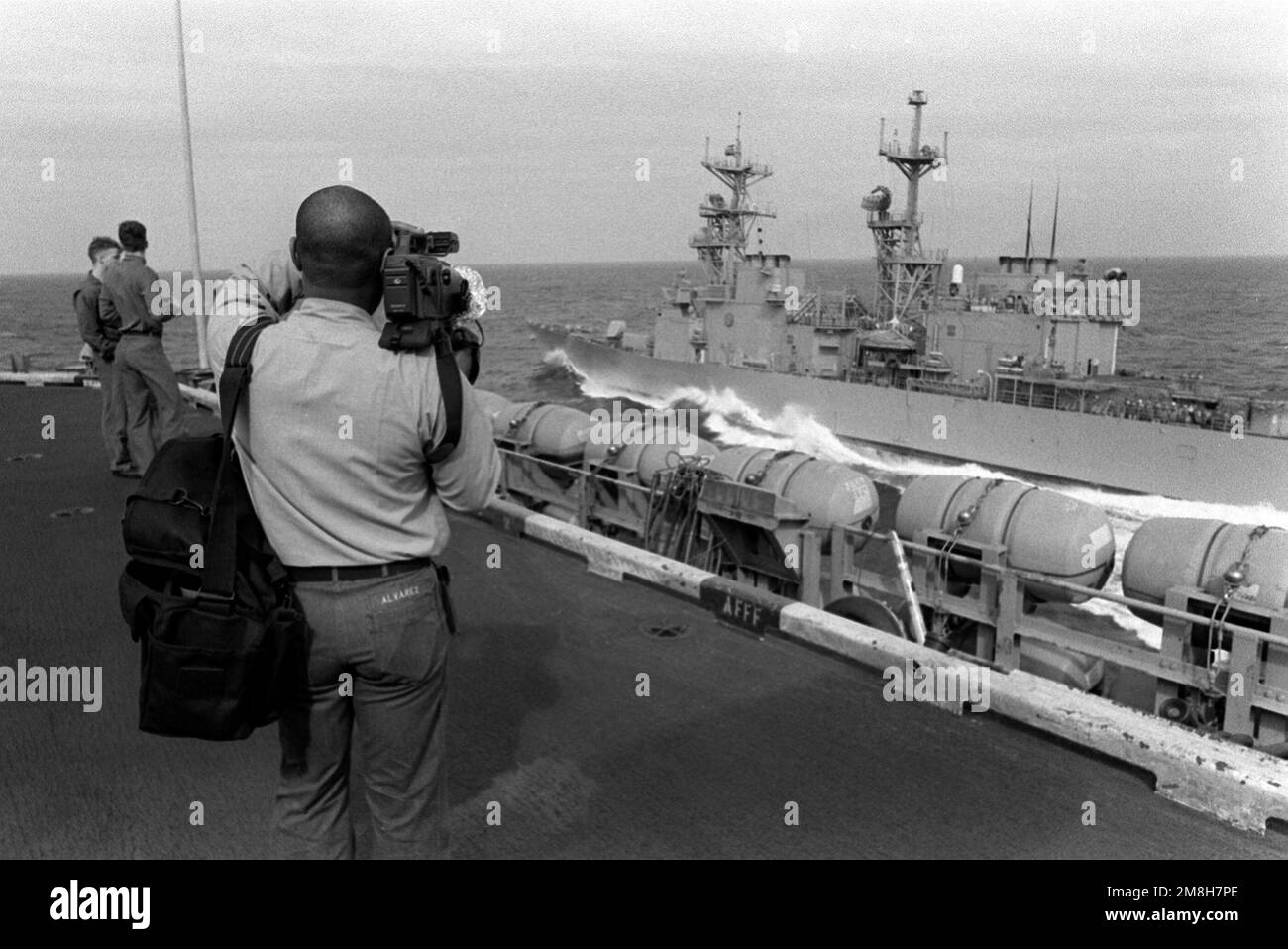 A sailor videotapes the destroyer USS LEFTWICH (DD-984) as the ship ...