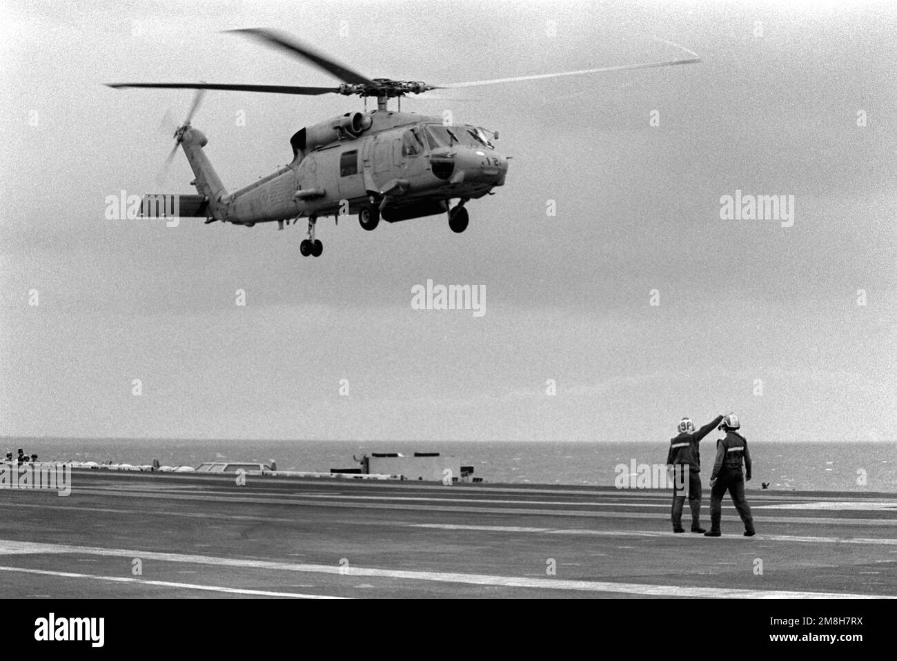Flight deck crewmen watch as a Helicopter Anti-submarine Squadron 2 (HS ...
