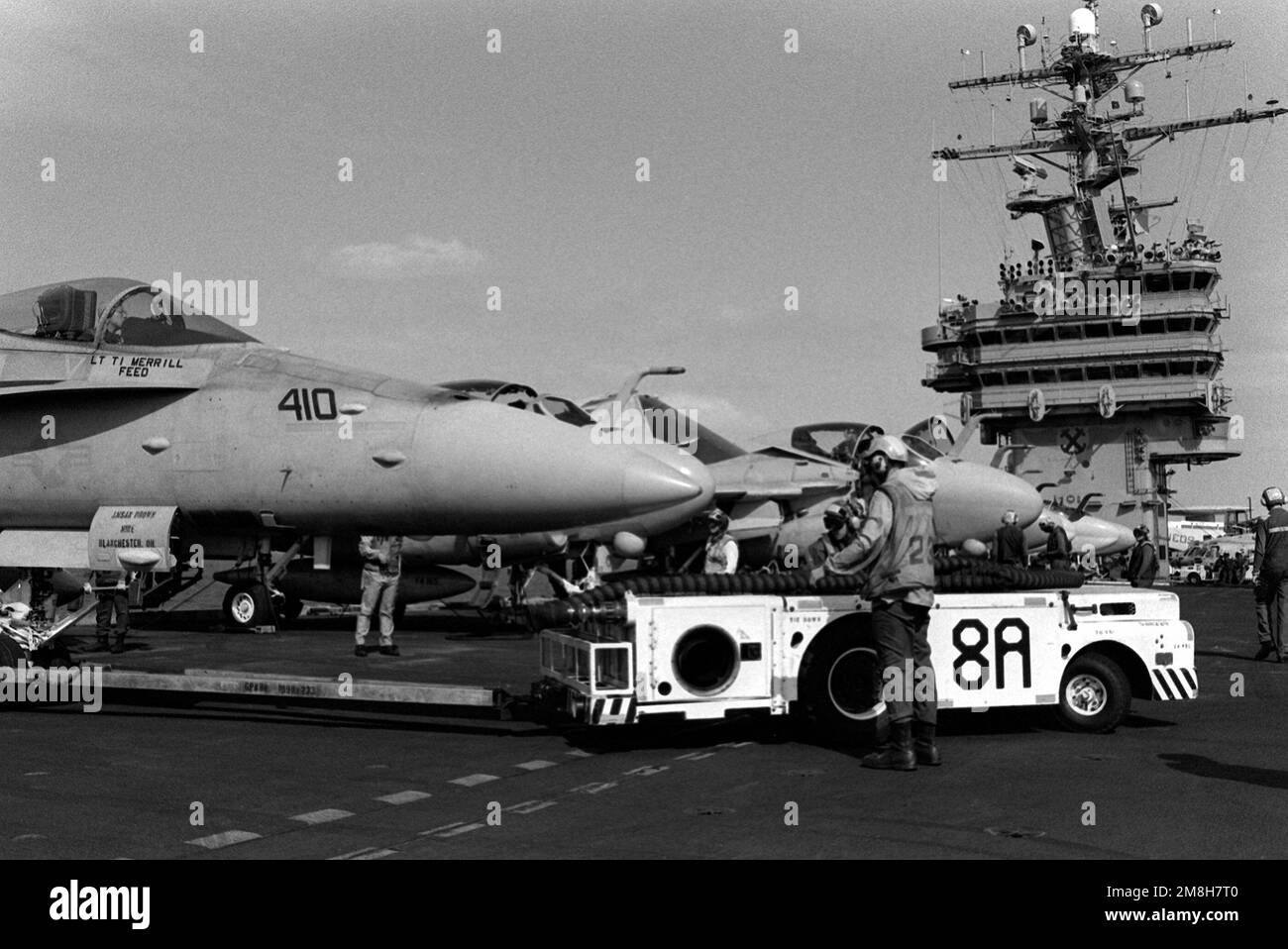 Flight deck crewmen use an MD-3 tow tractor to position a Strike ...