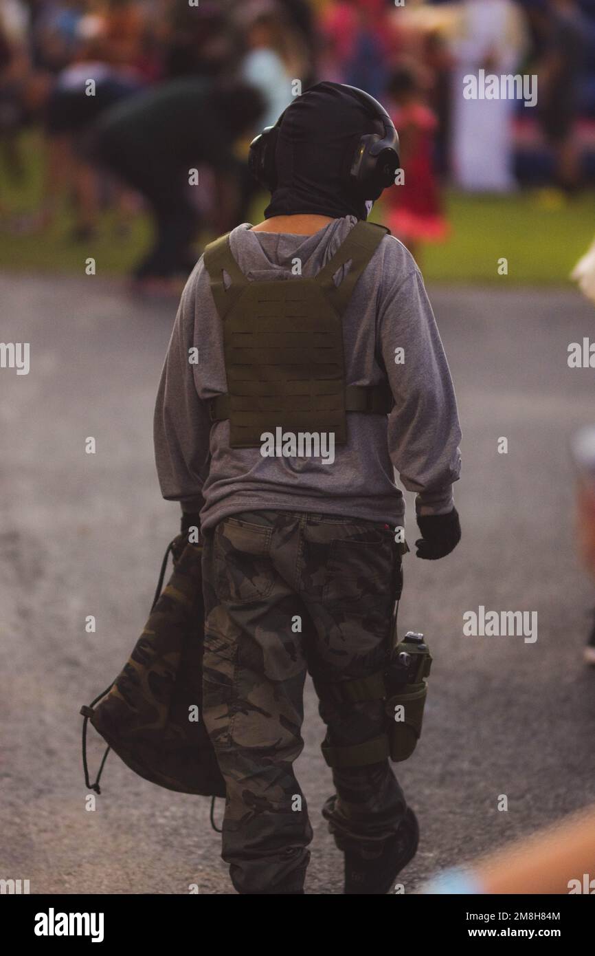 A back view of soldier wearing solider costume and walking in street ...