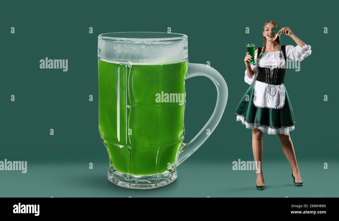 Beautiful Irish waitress and big mug of beer on green background. St ...