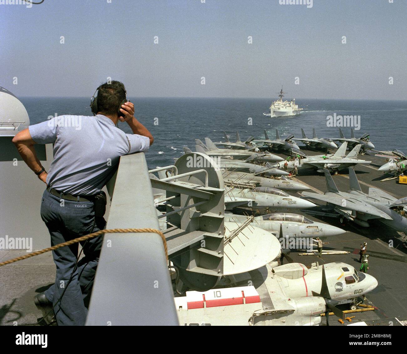 A crew member watches from the island as the miscellaneous flagship USS ...