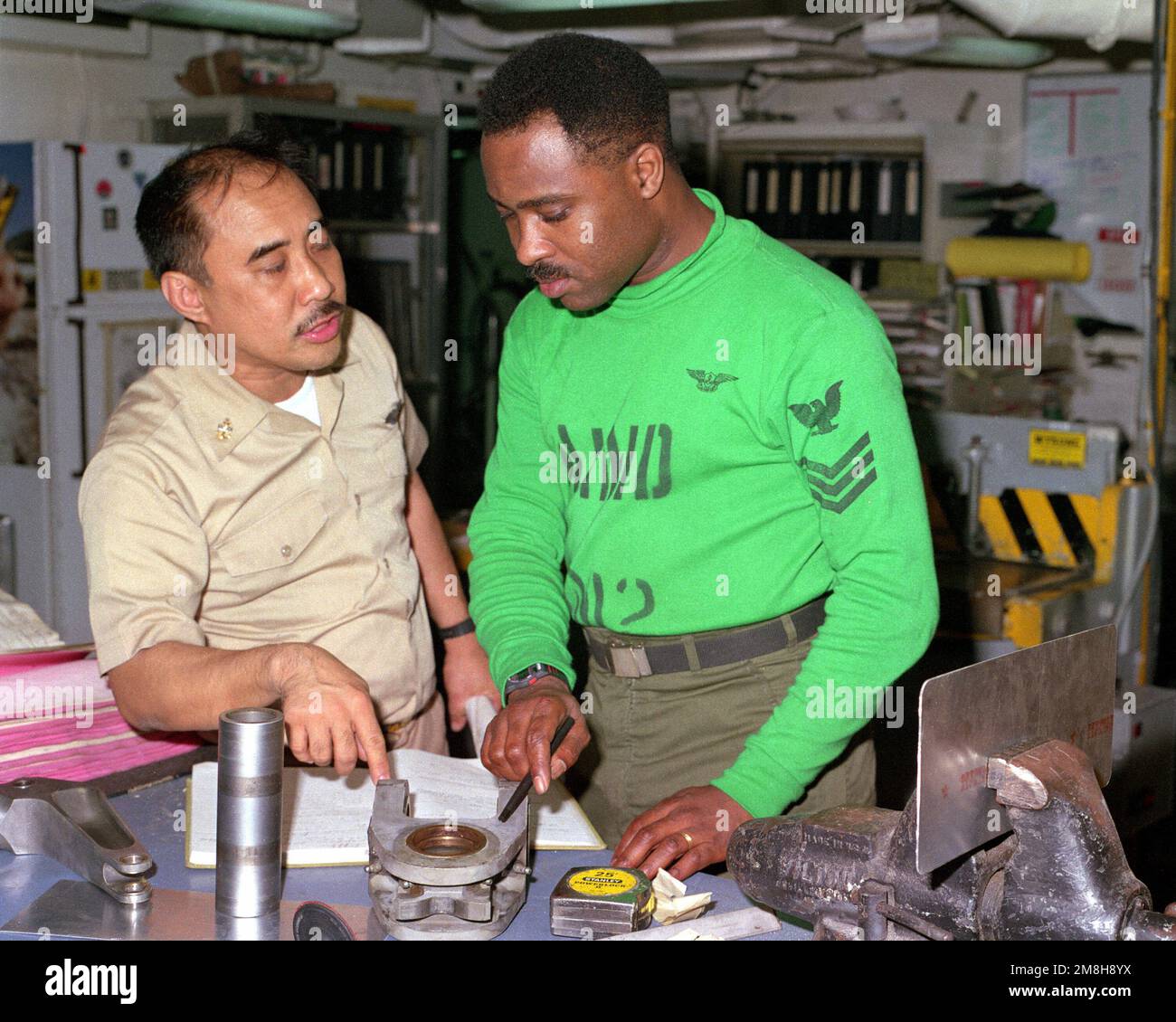 Crew members discuss the operation of a wheel spool in the Aircraft ...