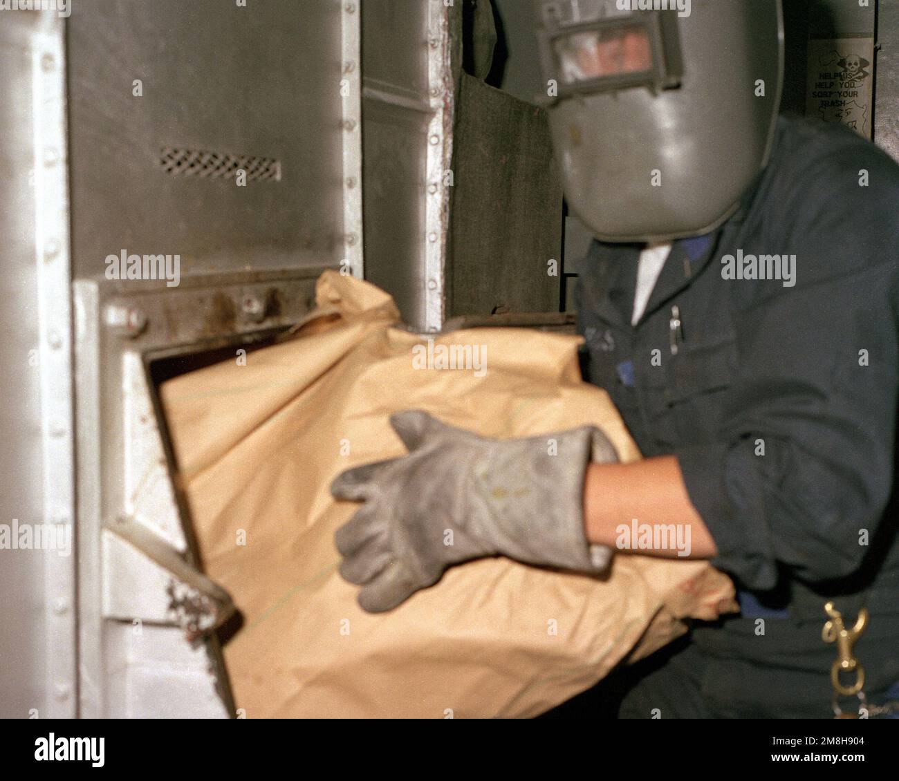 SEAMAN John Farias disposes of trash in an incinerator aboard the ...