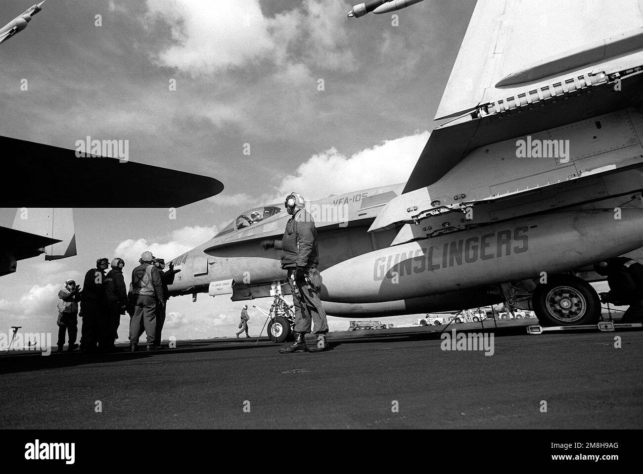 Flight deck crew members prepare for the movement of a Strike Fighter ...