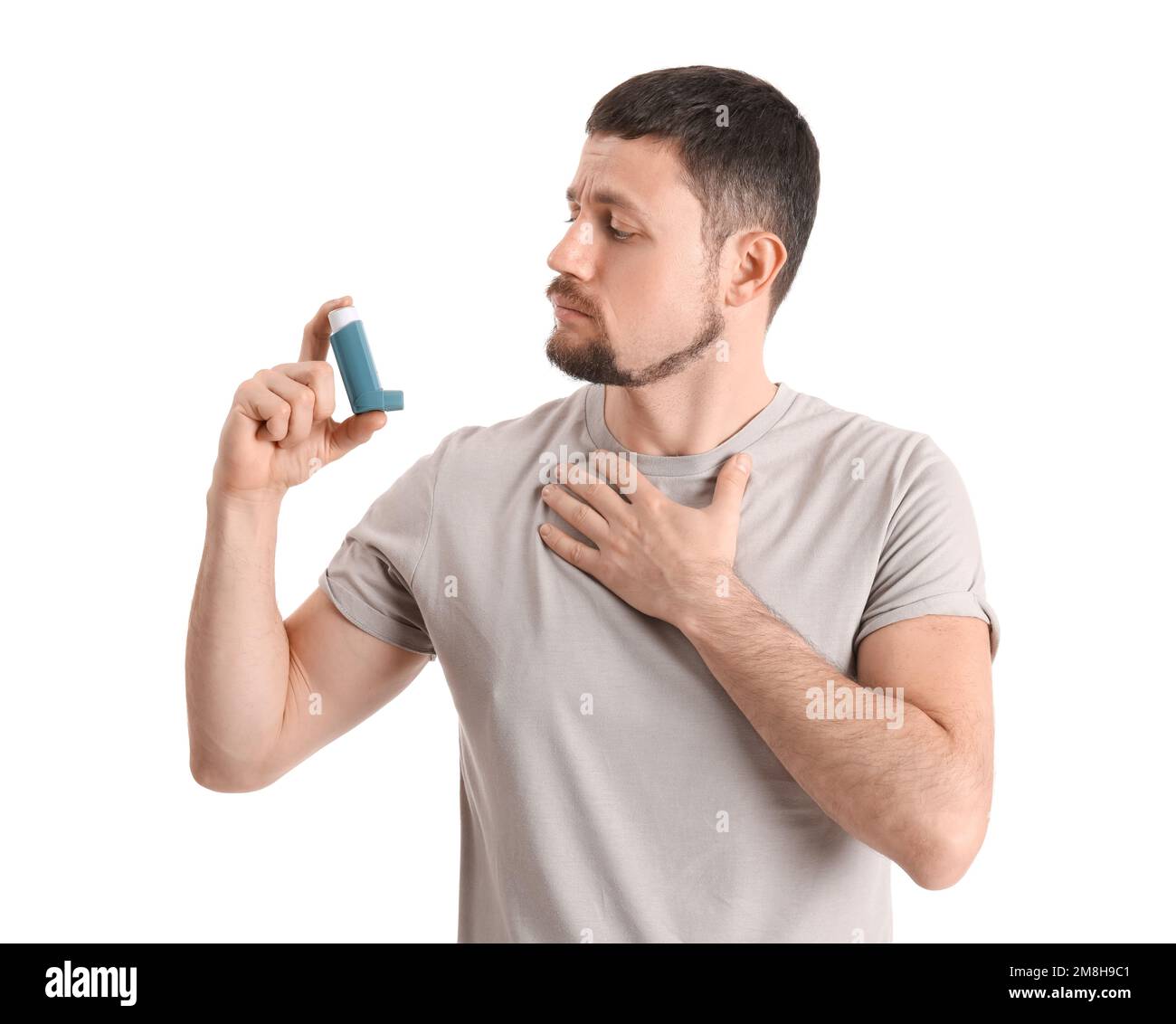 Sick man with inhaler on white background Stock Photo - Alamy