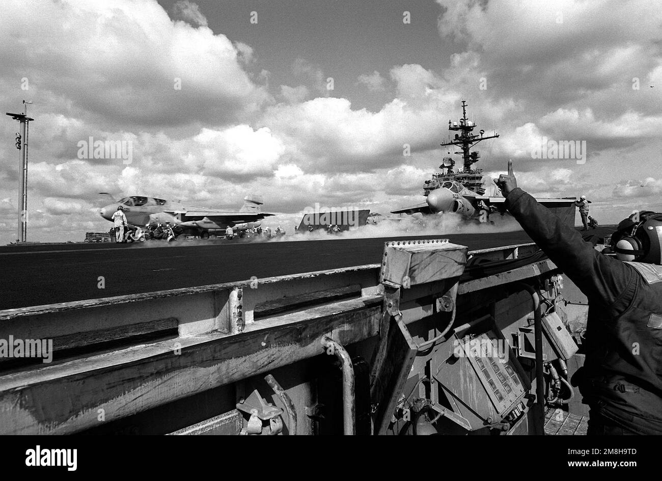 The port deck edge operator signals to the catapult officer as a ...