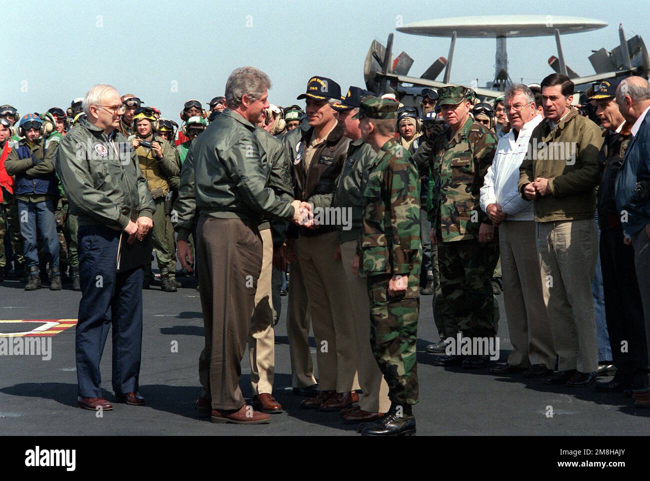 President William Jefferson Clinton shakes hands with a Navy officer ...