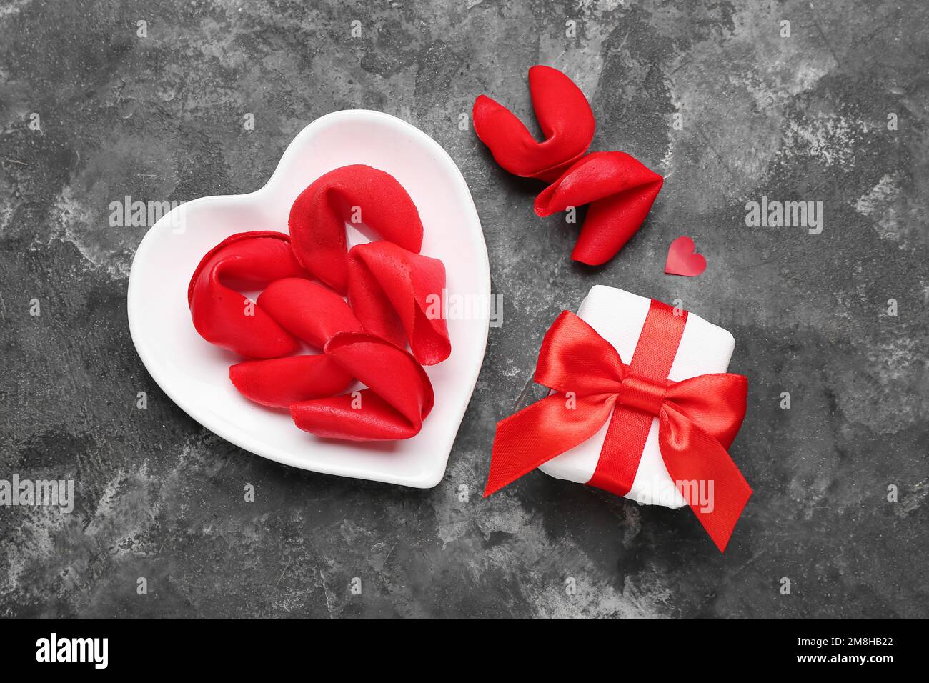 Plate with red fortune cookies and gift on dark background. Valentine's ...