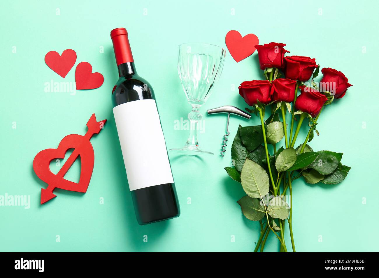 Bottle of wine, rose flowers and hearts on turquoise background ...